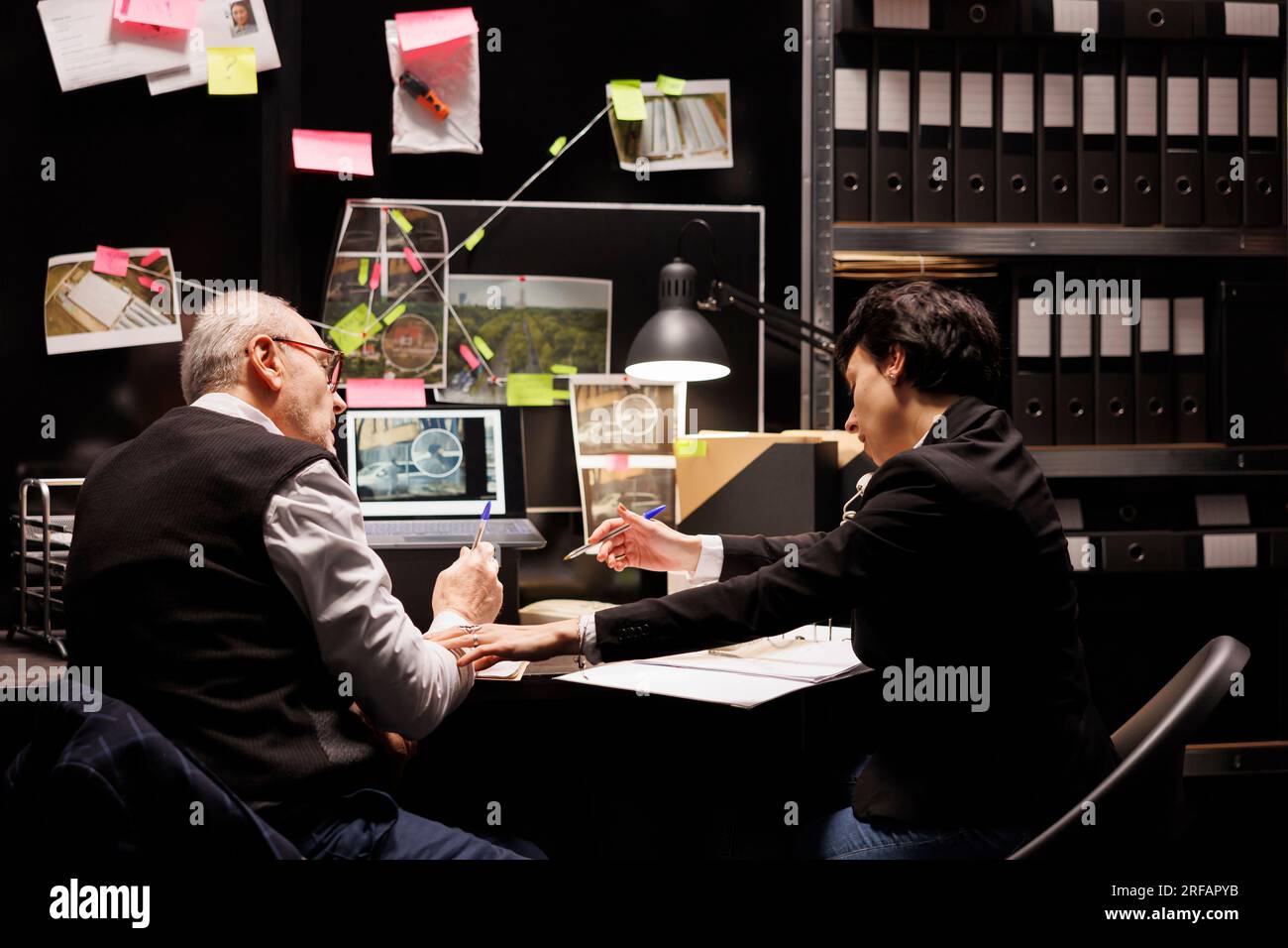 Old investigator analyzing federal documents with inspector, discussing ...