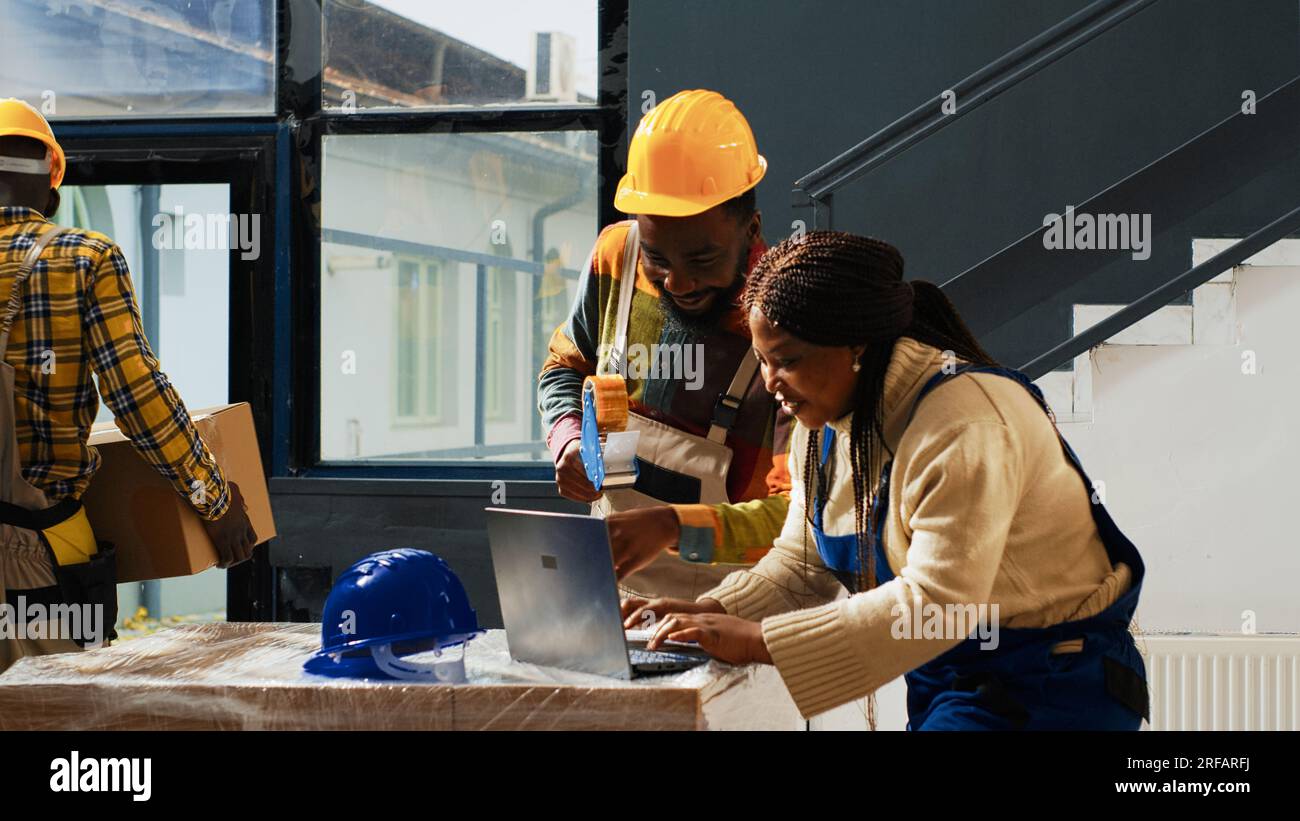 Team of people using racks to stack cardboard boxes, packing goods and ...