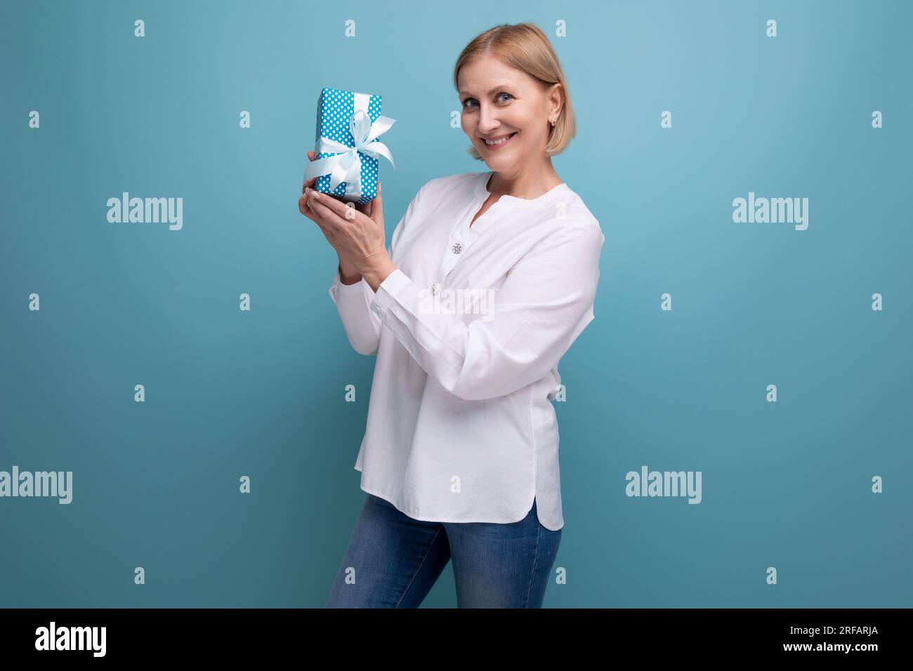 happy 50s woman received surprise gift in box on studio background ...