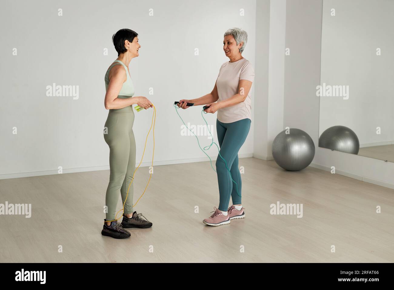 Mature women jumping on skipping rope in health club Stock Photo - Alamy