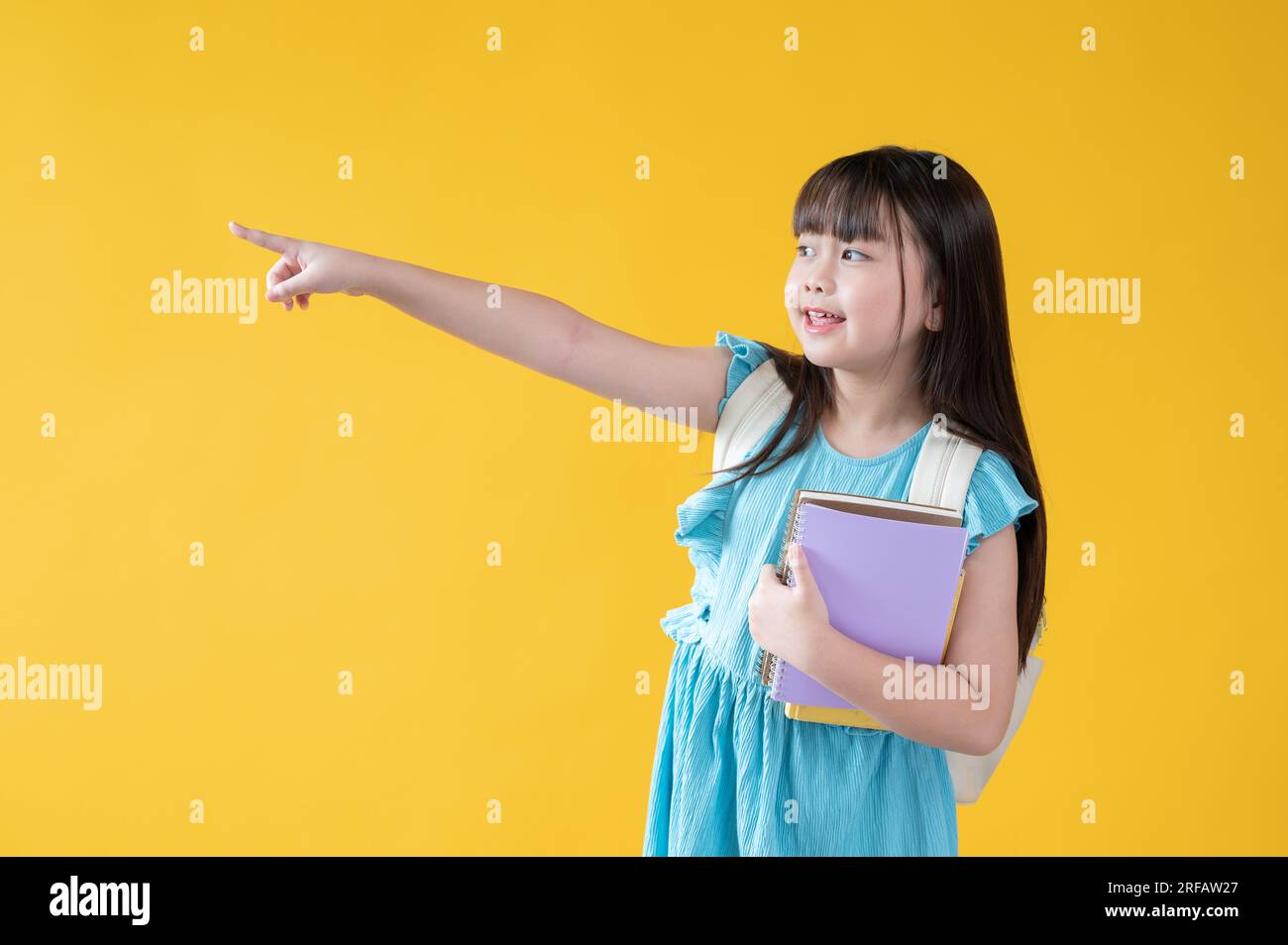 An adorable young Asian girl or elementary school student with books in ...