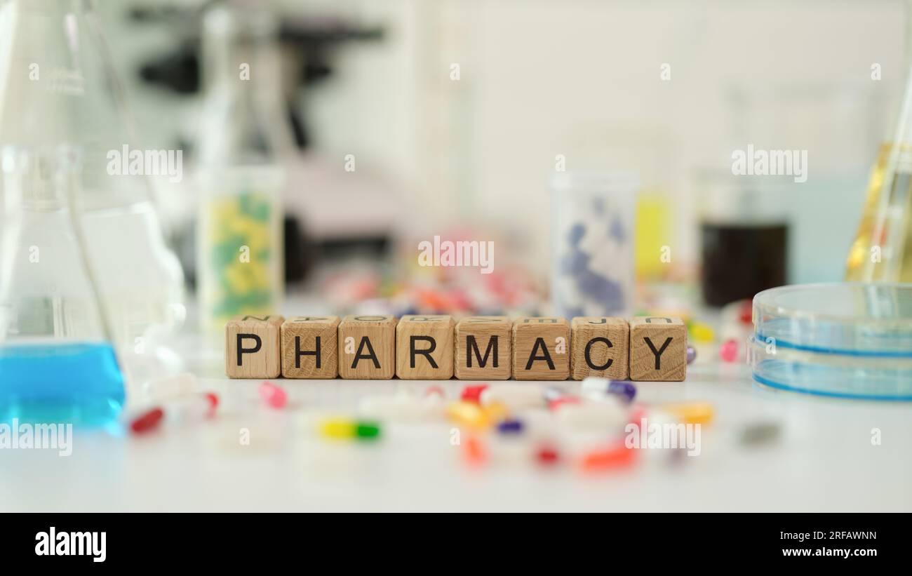 Word pharmacy with medical pills and microscope and laboratory ...