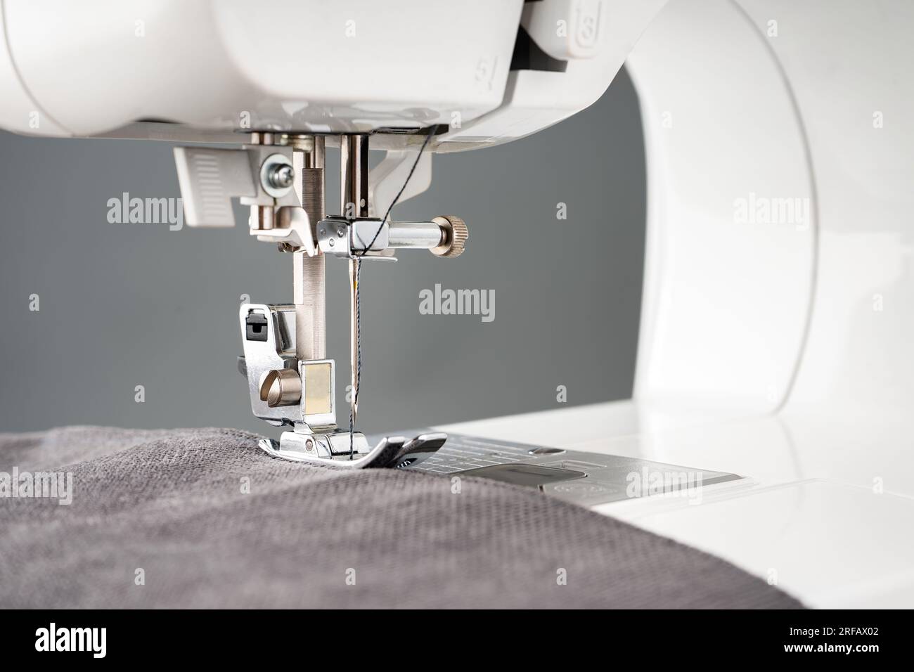 Modern sewing machine with gray fabric and. Sewing process clothes ...