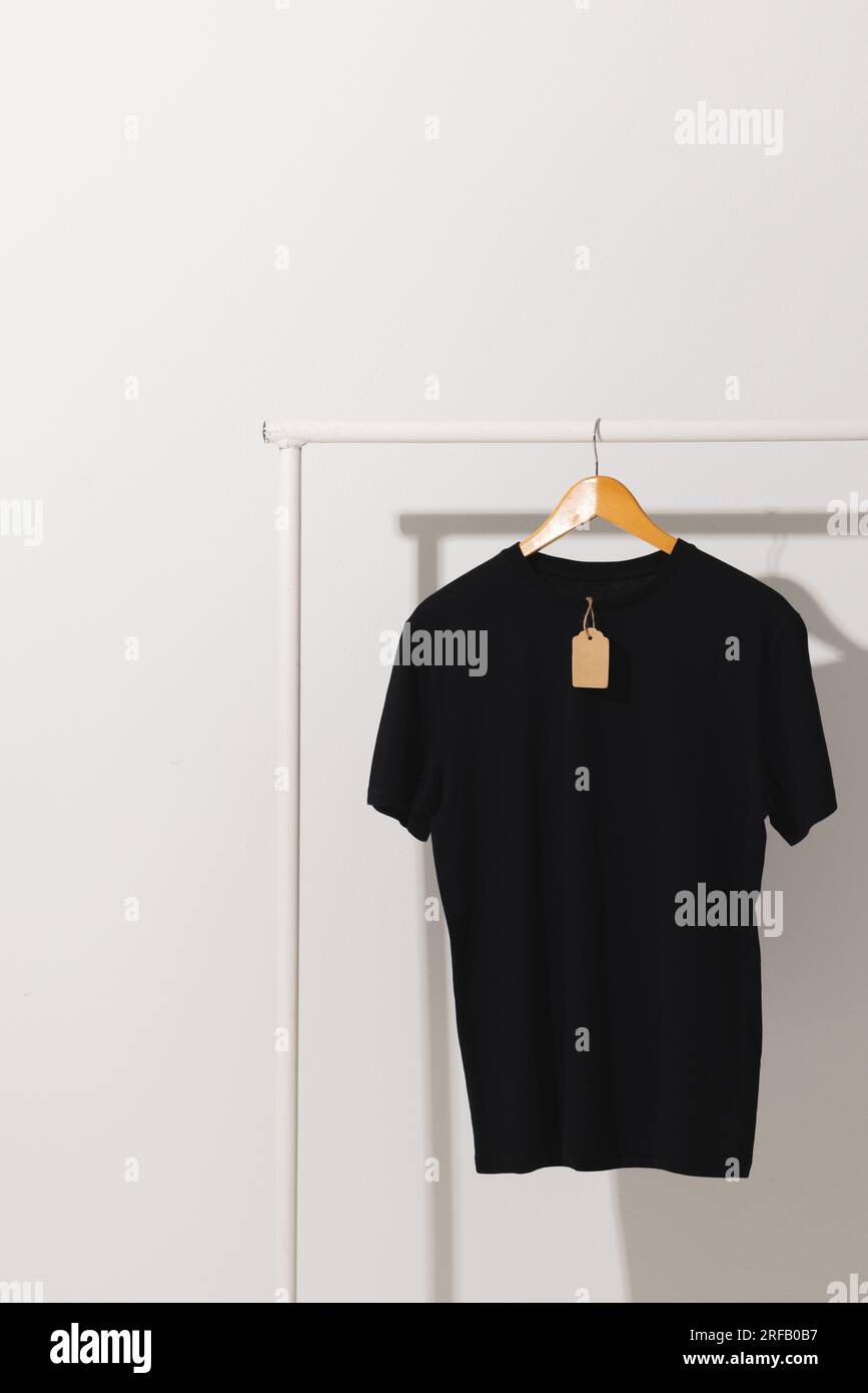 Black t shirt with tag hanging from clothes rack with copy space on ...