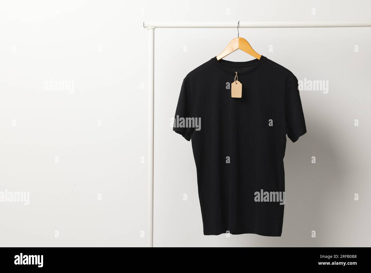 Black t shirt with tag hanging from clothes rack with copy space on ...