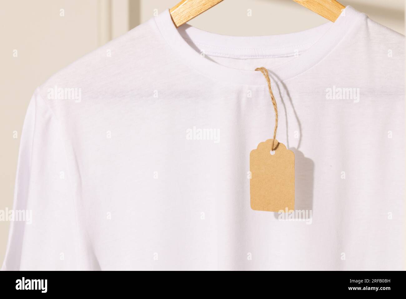 White t shirt with tag hanging from clothes rack with copy space on ...