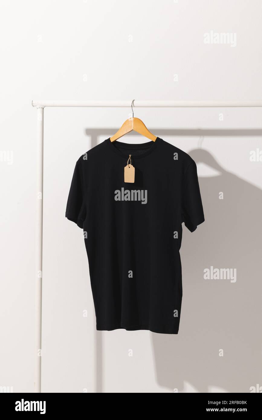 Black t shirt with tag hanging from clothes rack with copy space on ...