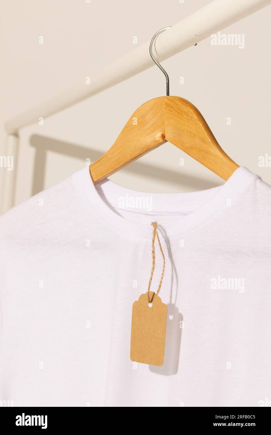 White t shirt with tag hanging from clothes rack with copy space on ...