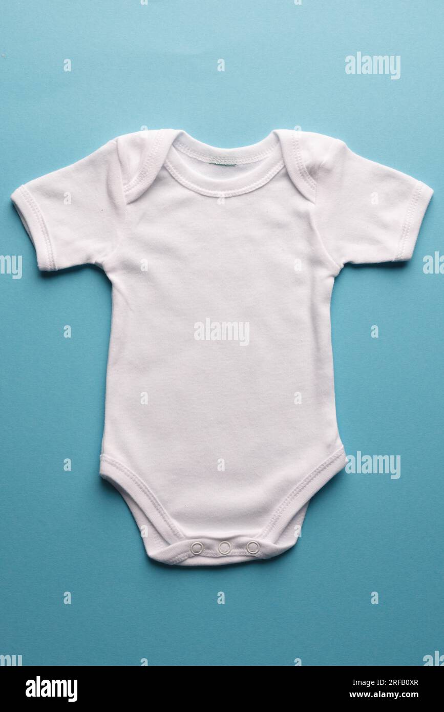 Flat lay of white baby grow with copy space on blue background Stock ...