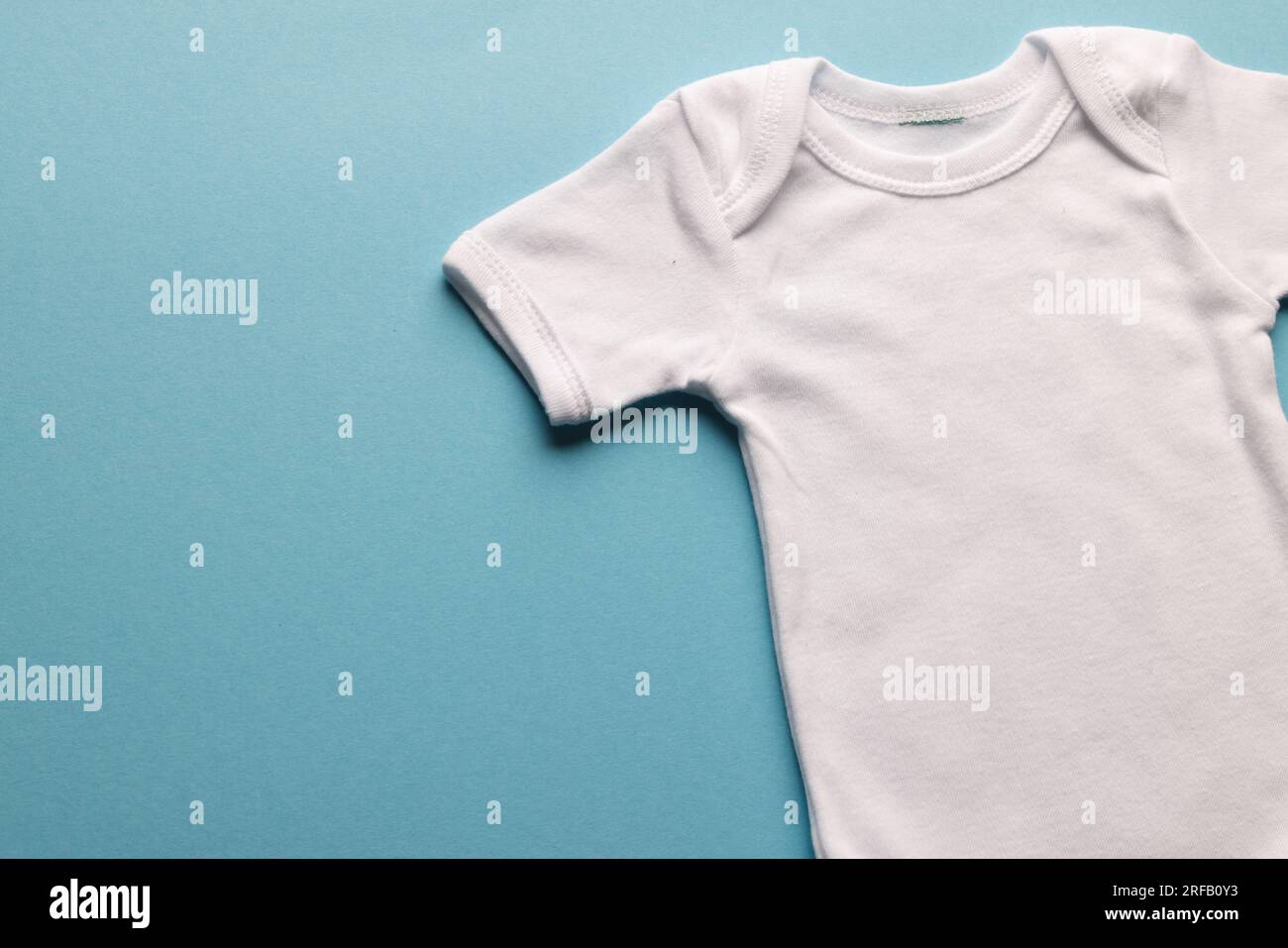 Flat lay of white baby grow with copy space on blue background Stock ...