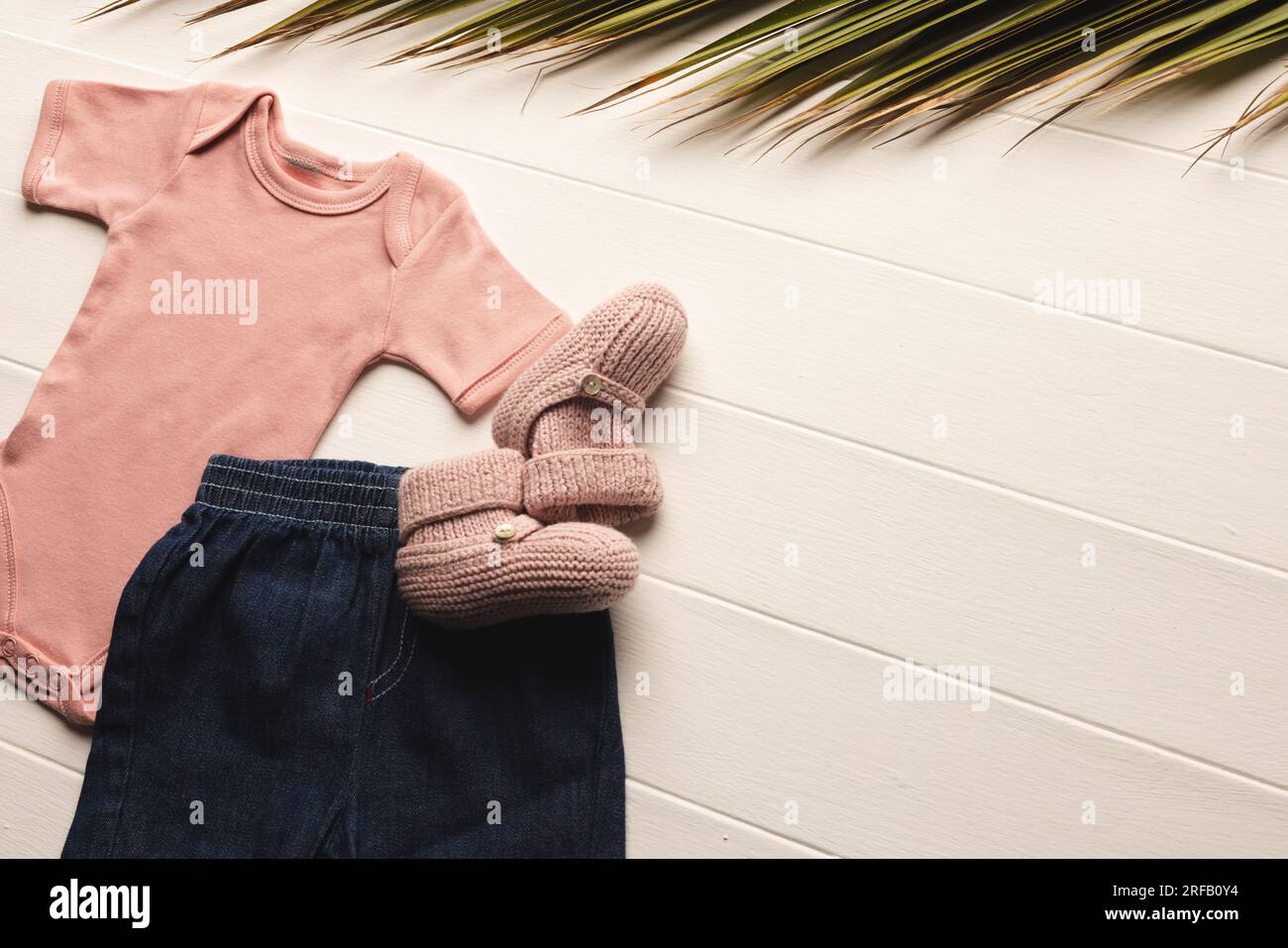 Flat lay of pink baby grow, shorts and pink booties with copy space on ...