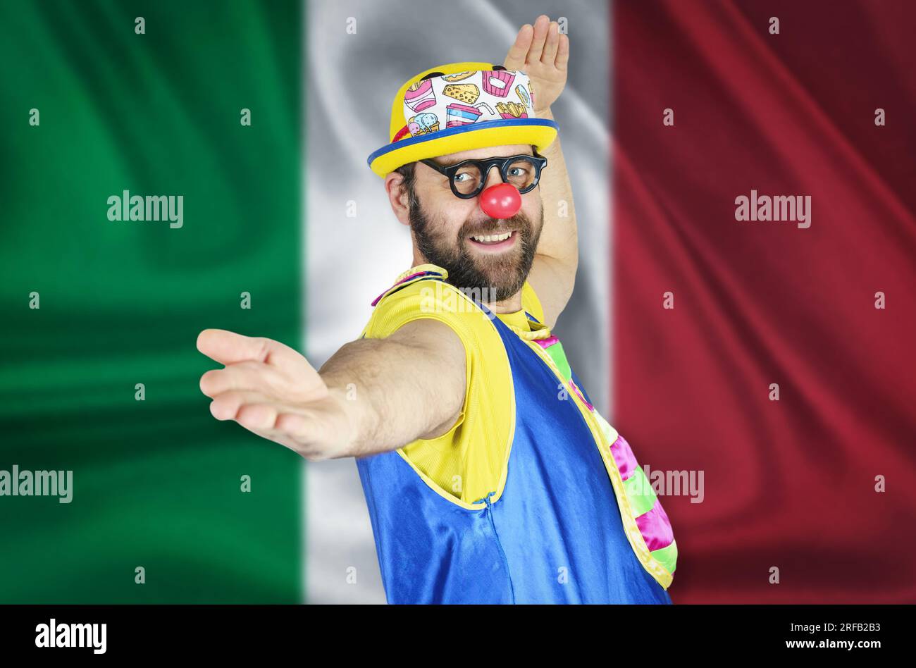 A cheerful clown stands in a welcoming pose against the background of ...