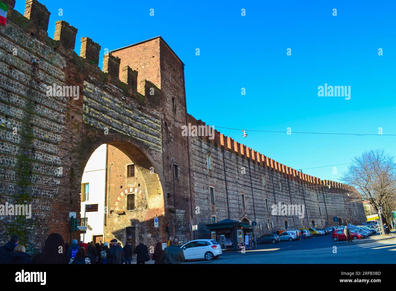 Gate in old Roman fortress wall and cars driving on road under it ...