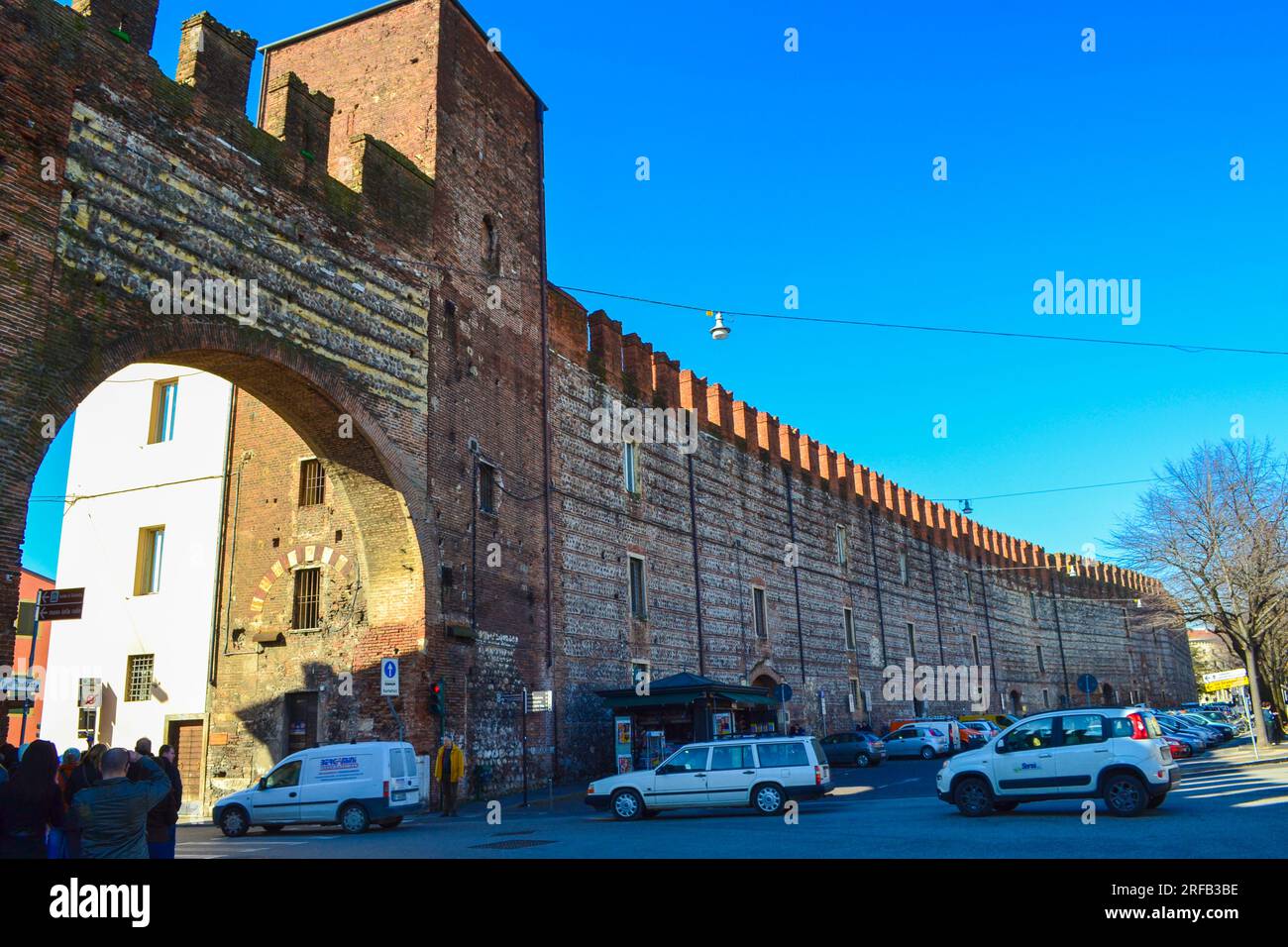 Gate in old Roman fortress wall and cars driving on road under it ...