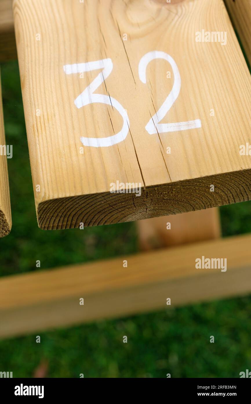 Numbers painted oon wooden benches in a pub garden in the UK to ...