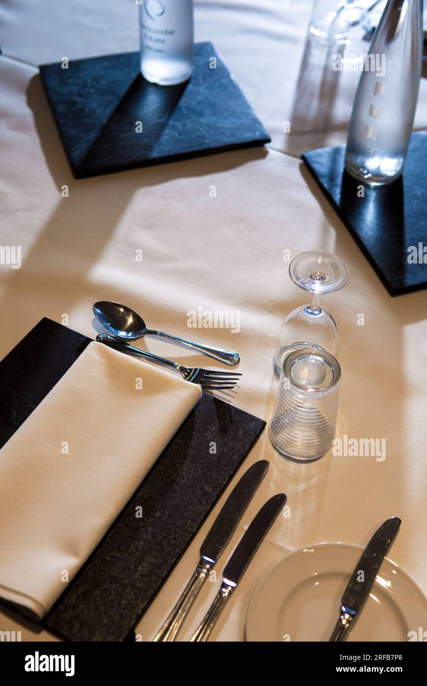 A large dining table set out with place settgings ready for a large ...