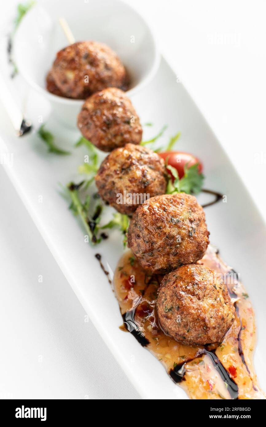 thai fish cake balls in gourmet contemporary restaurant on white plate ...