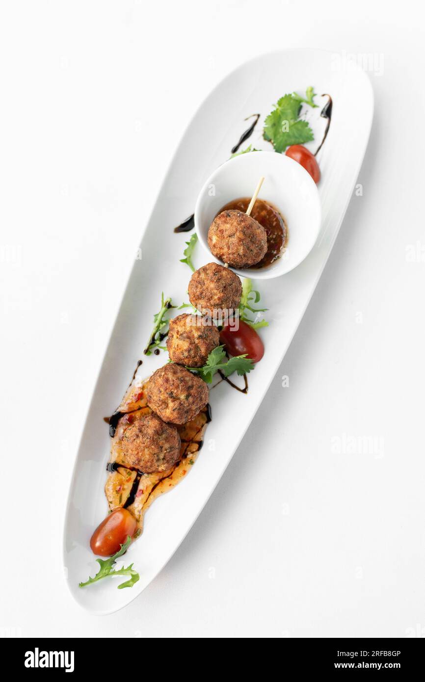 thai fish cake balls in gourmet contemporary restaurant on white plate ...