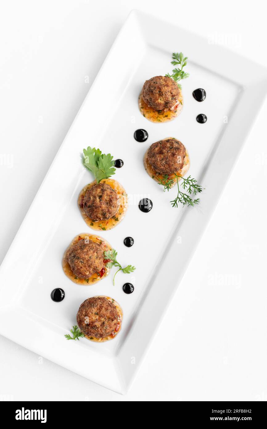 thai fish cake balls in gourmet contemporary restaurant on white plate ...