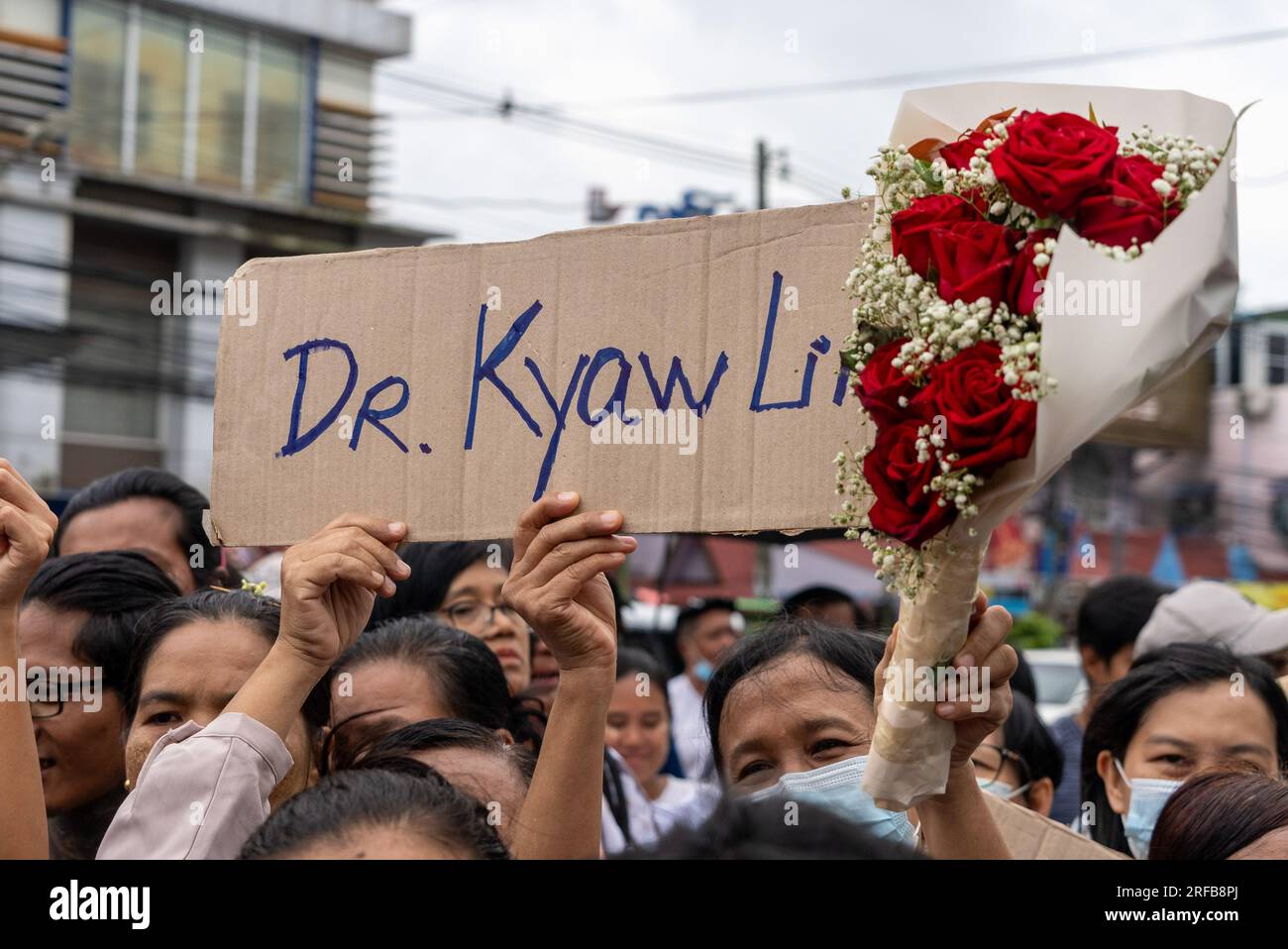 Family members hold a placard and flowers as they gather outside the ...