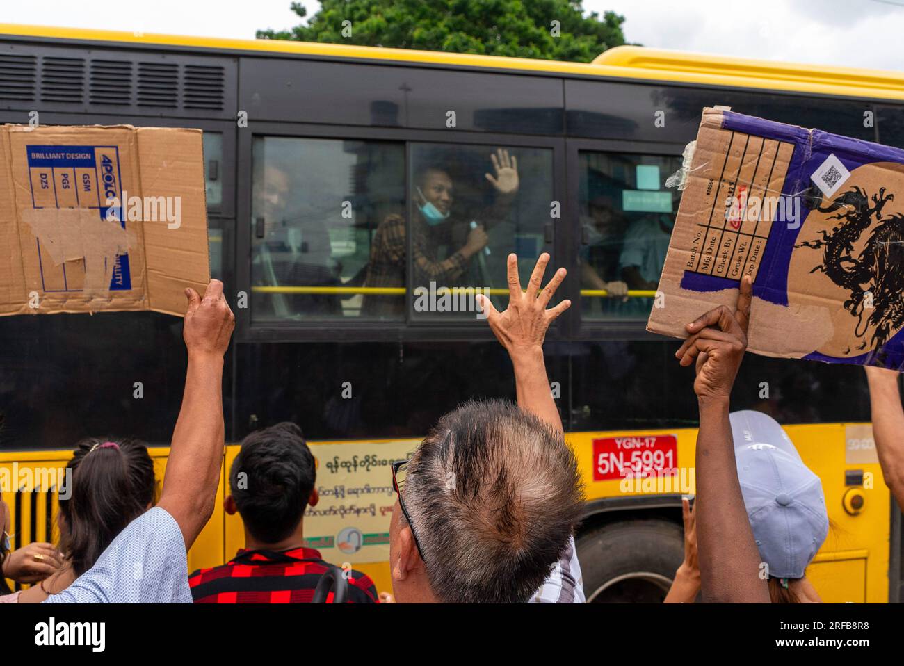 Yangon, Myanmar. 01st Aug, 2023. Family members wave and hold placards ...
