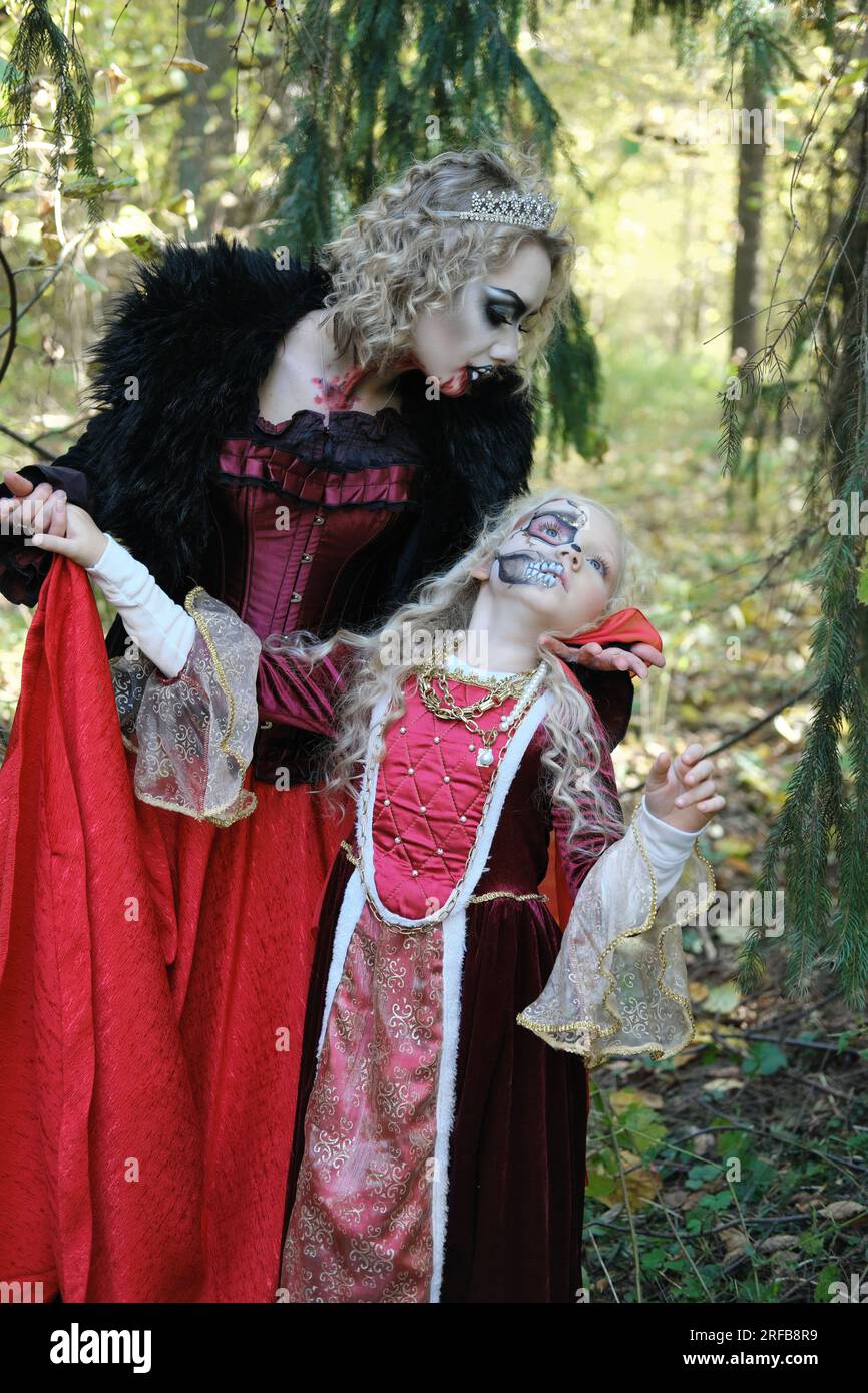 A woman in the form of a vampire or a sorceress poses in the forest ...