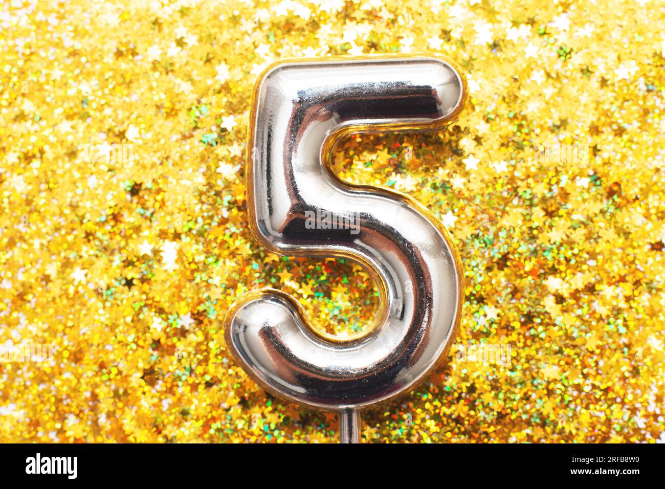 Five years birthday party. Festive silver big number five with golden ...