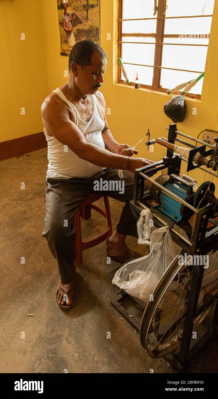 Man demonstrating how to spin silk into threads in Sualkuchi, a small ...
