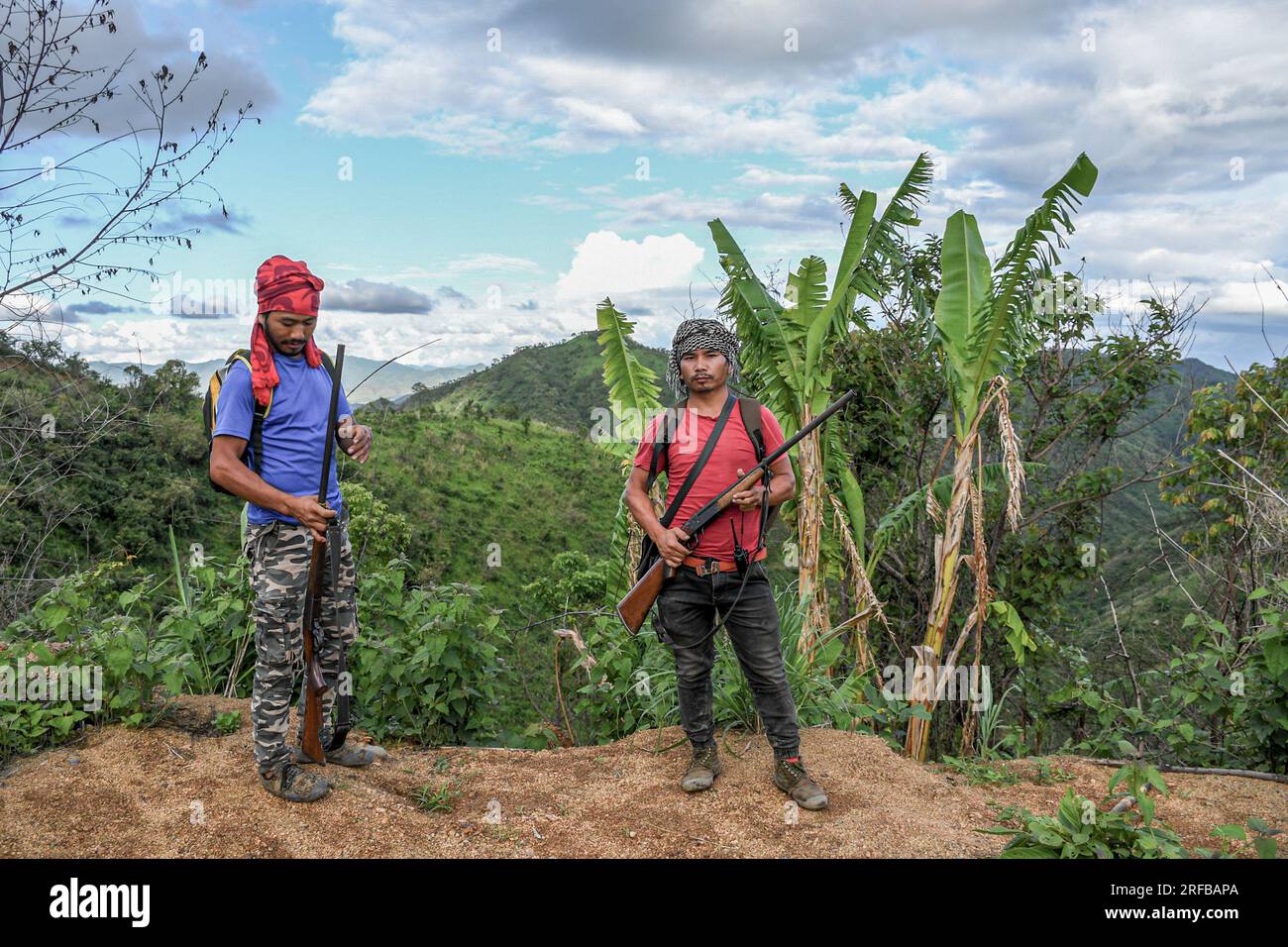 Armed Kuki men reacts to the camera as they guard a village in ...