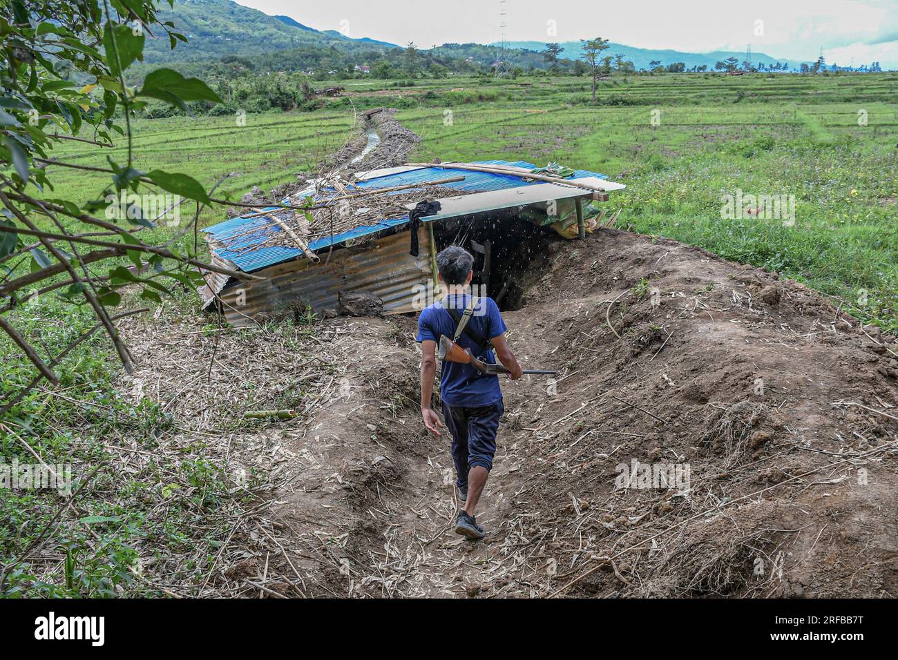 An armed Kuki man, walks as he guards a village in Churachandpur ...