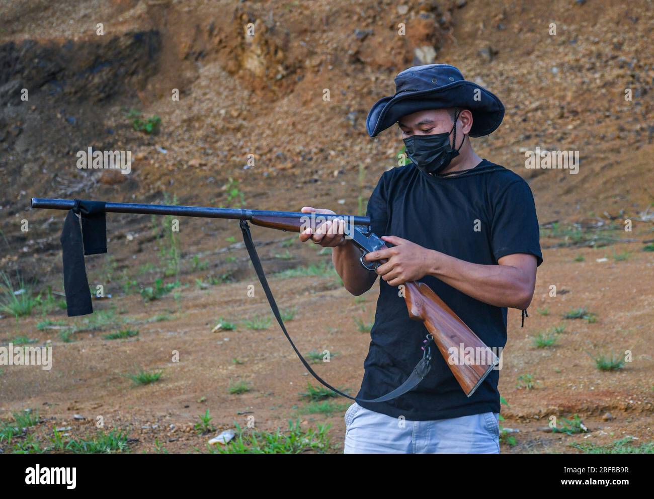 An armed Kuki man loads a cartridge into a single-barreled rifle during ...