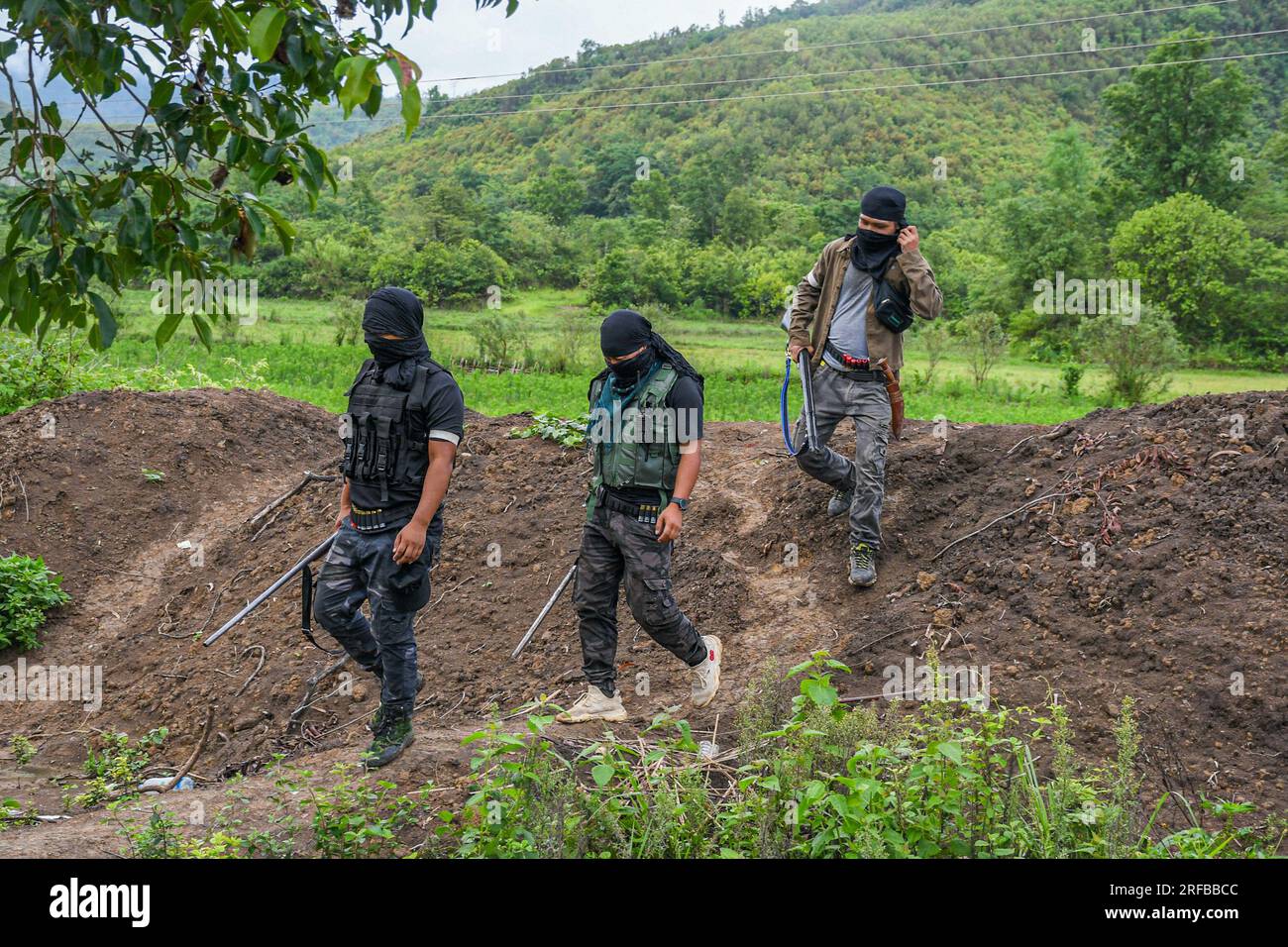 Armed Kuki men walk while guarding Dampi village in Churachandpur ...