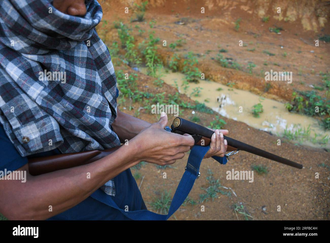 An armed Kuki man loads a cartridge into a single-barreled rifle during ...