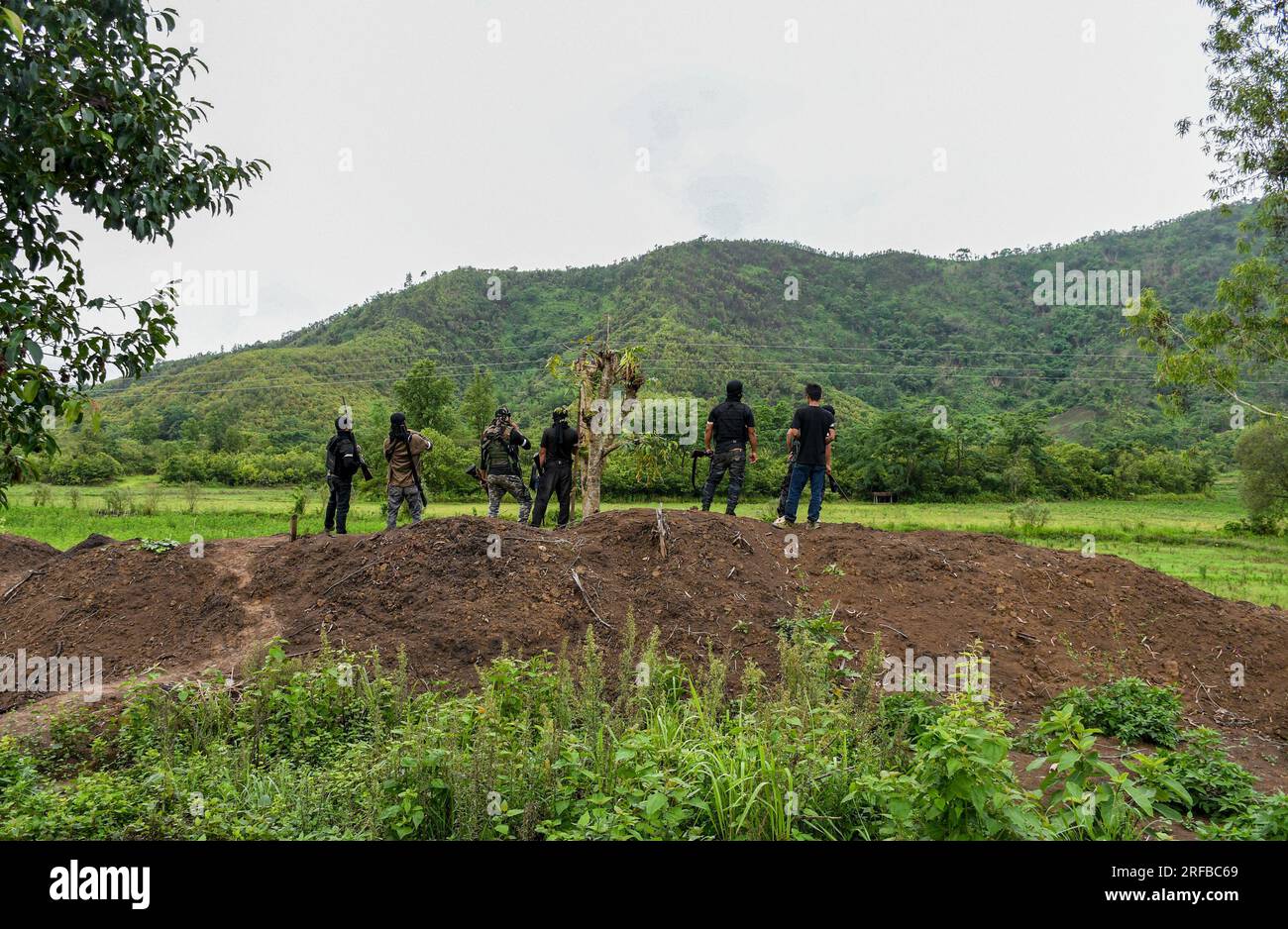 Armed members of the Kuki-Zo tribe take a break while looking at the ...
