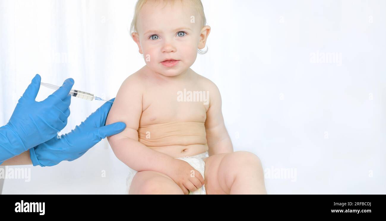 Doctor vaccinating baby in clinic. Little baby get an injection ...
