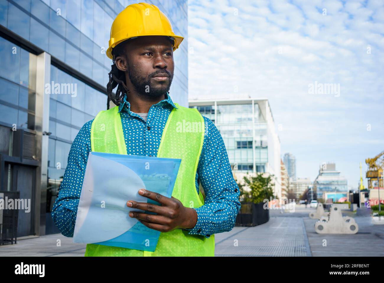 portrait of black man with beard and dreadlocks, architect in yellow ...