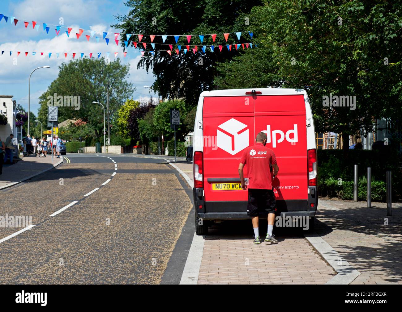 Man opening the rear door of a DPD delivery van in the village of ...