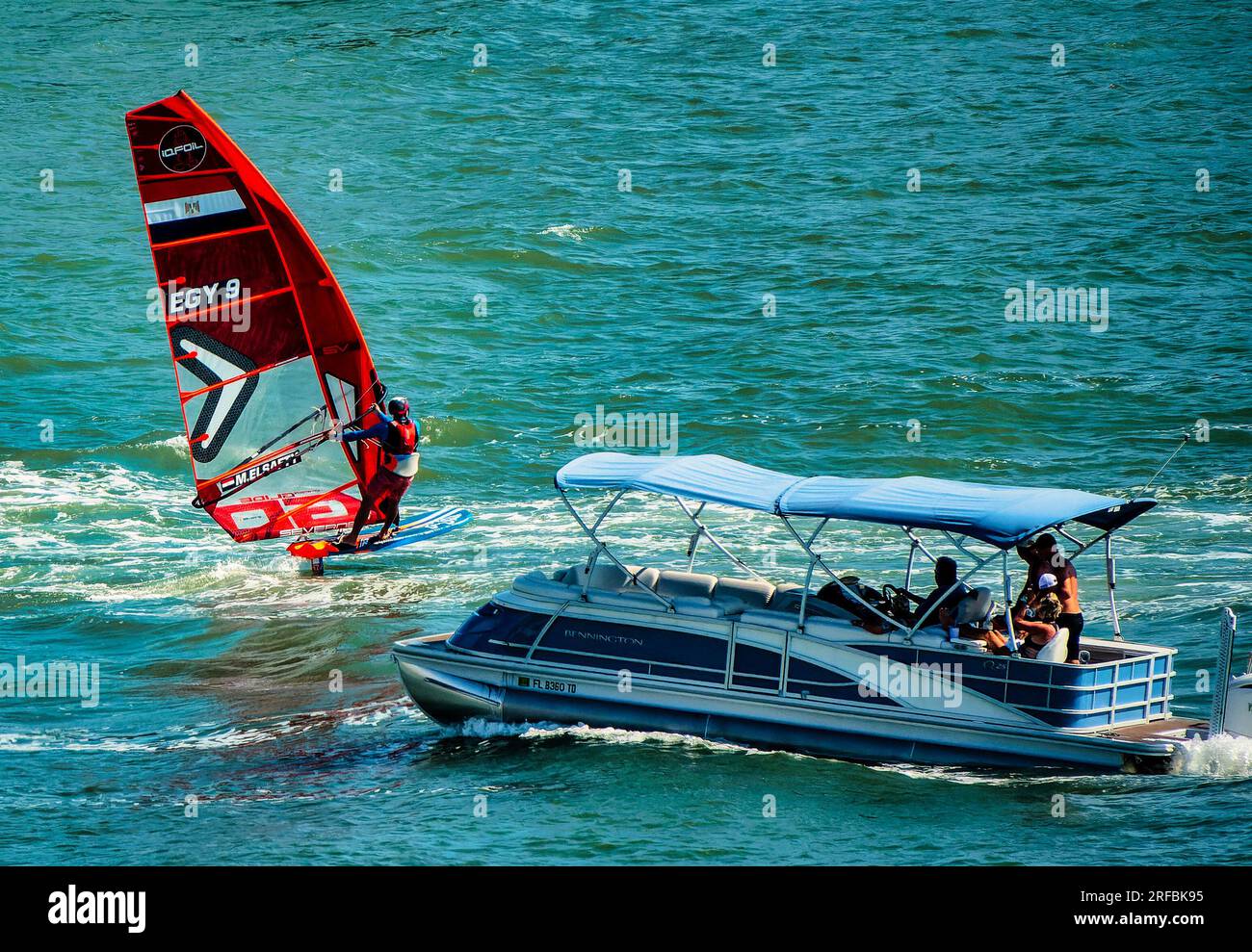 Wind surfer on the board passing a boat Stock Photo - Alamy