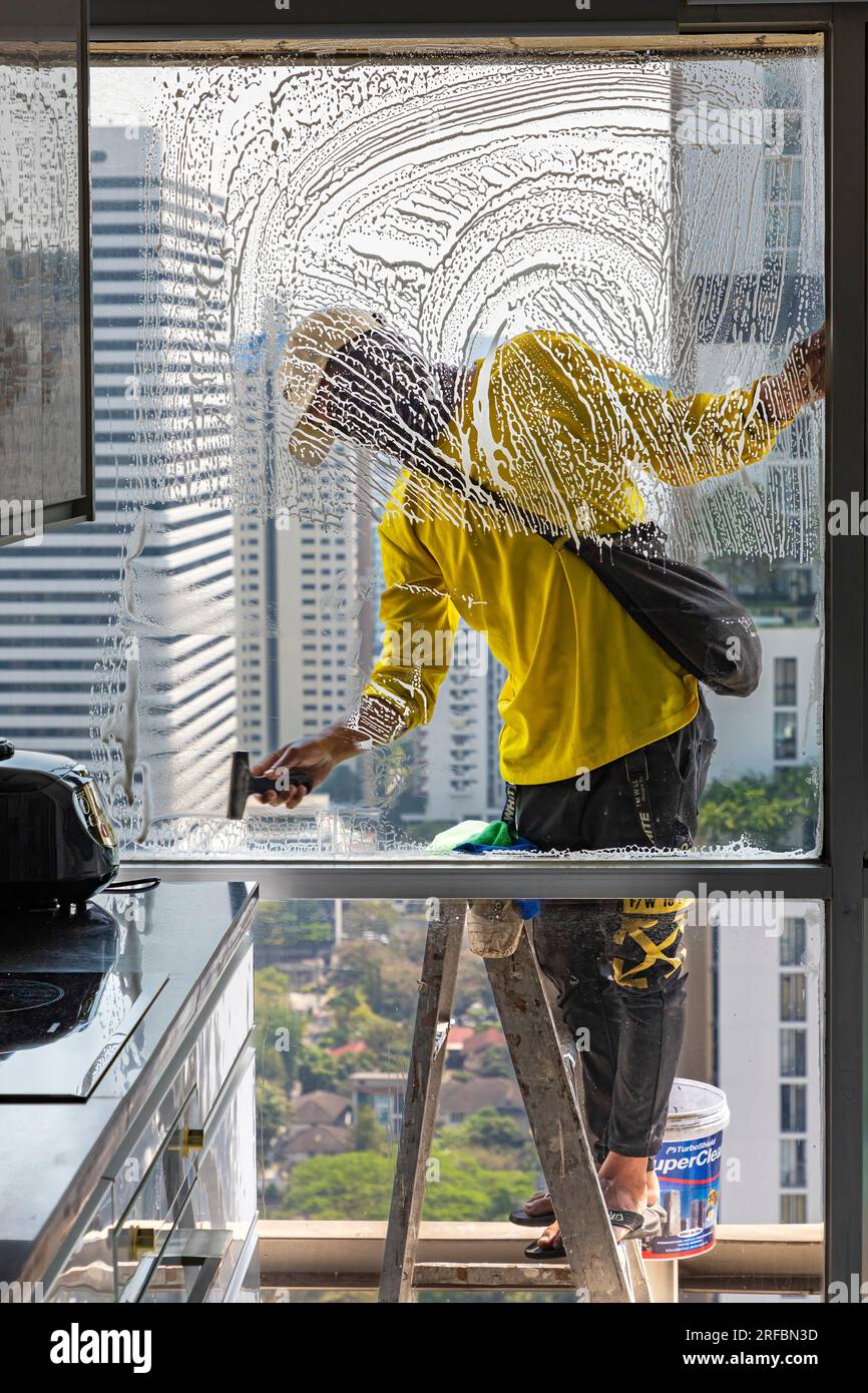 Thai window cleaner working on high rise building overlooking Sukhumvit ...