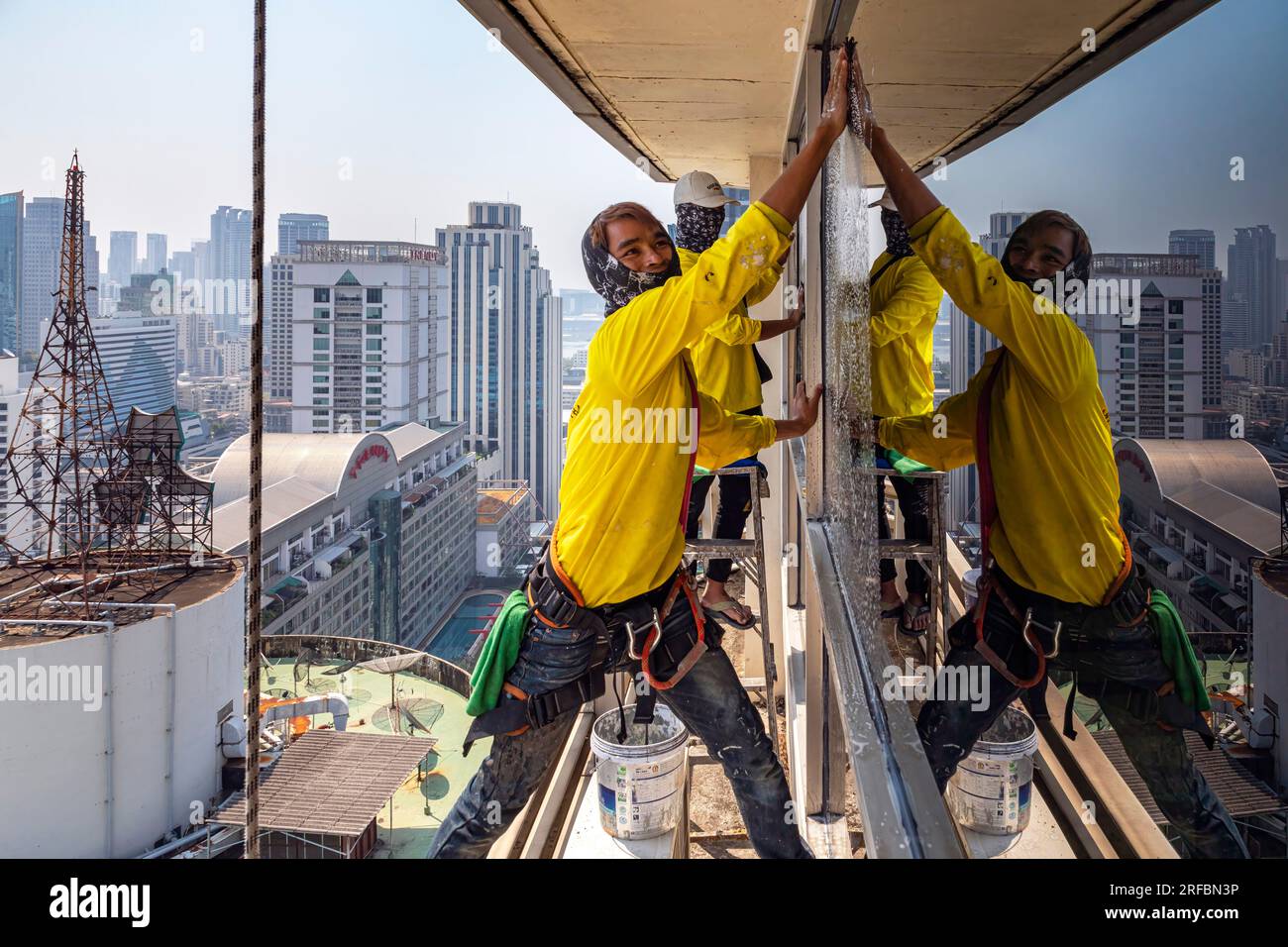 Thai window cleaner working on high rise building overlooking Sukhumvit ...