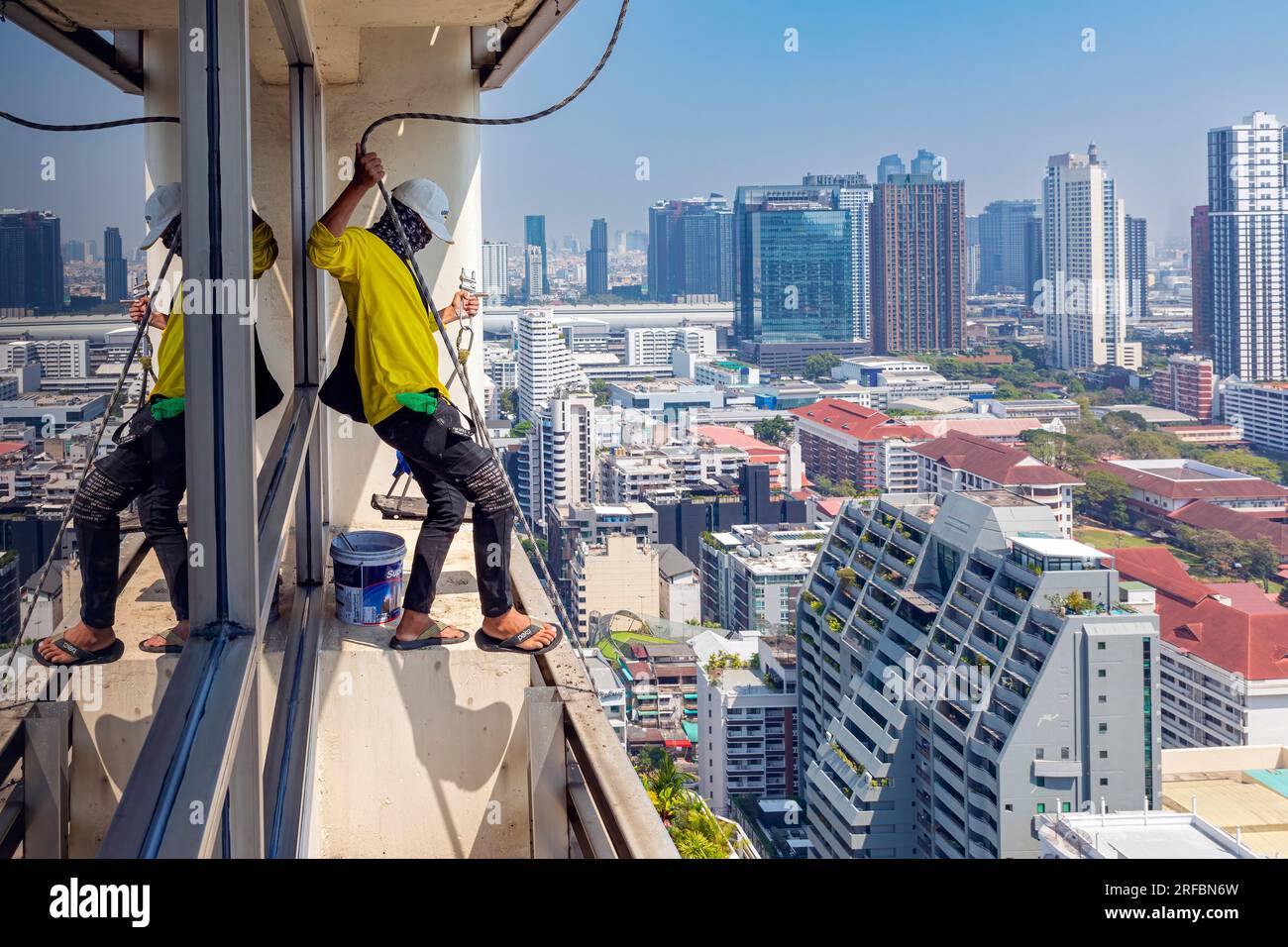 Thai maintenance worker abseiling outside high rise building, Sukhumvit ...