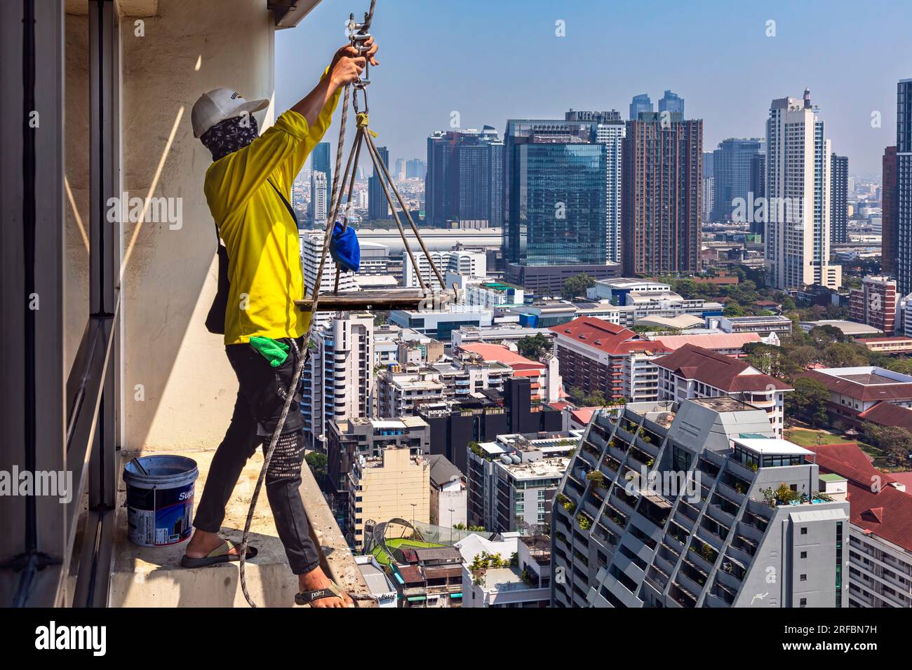 Thai maintenance worker abseiling outside high rise building, Sukhumvit ...