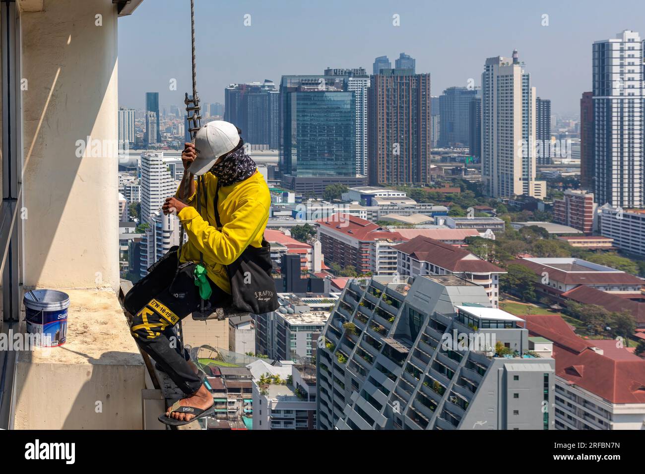 Thai maintenance worker abseiling outside high rise building, Sukhumvit ...