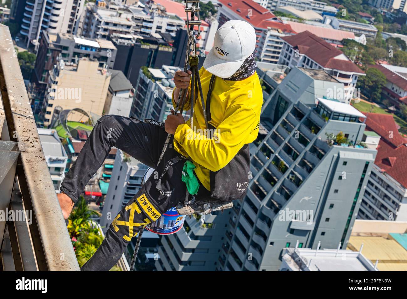 Thai maintenance worker abseiling outside high rise building, Sukhumvit ...