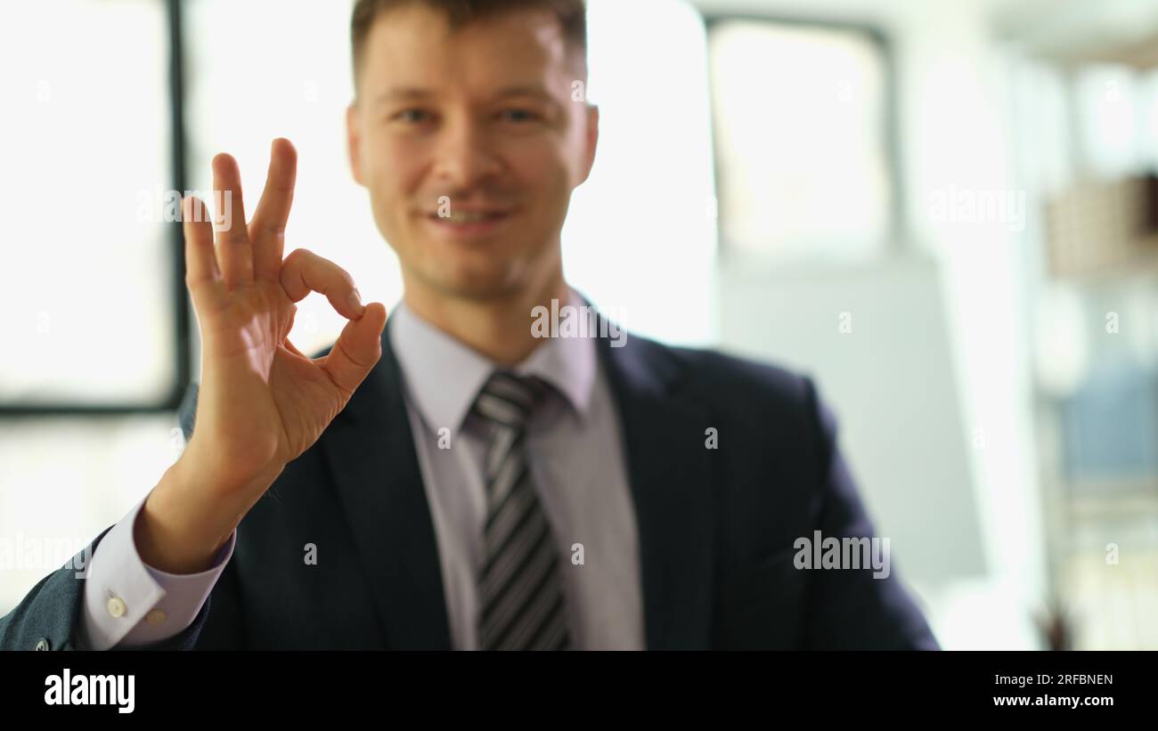 Smiling businessman showing ok sign Stock Photo - Alamy