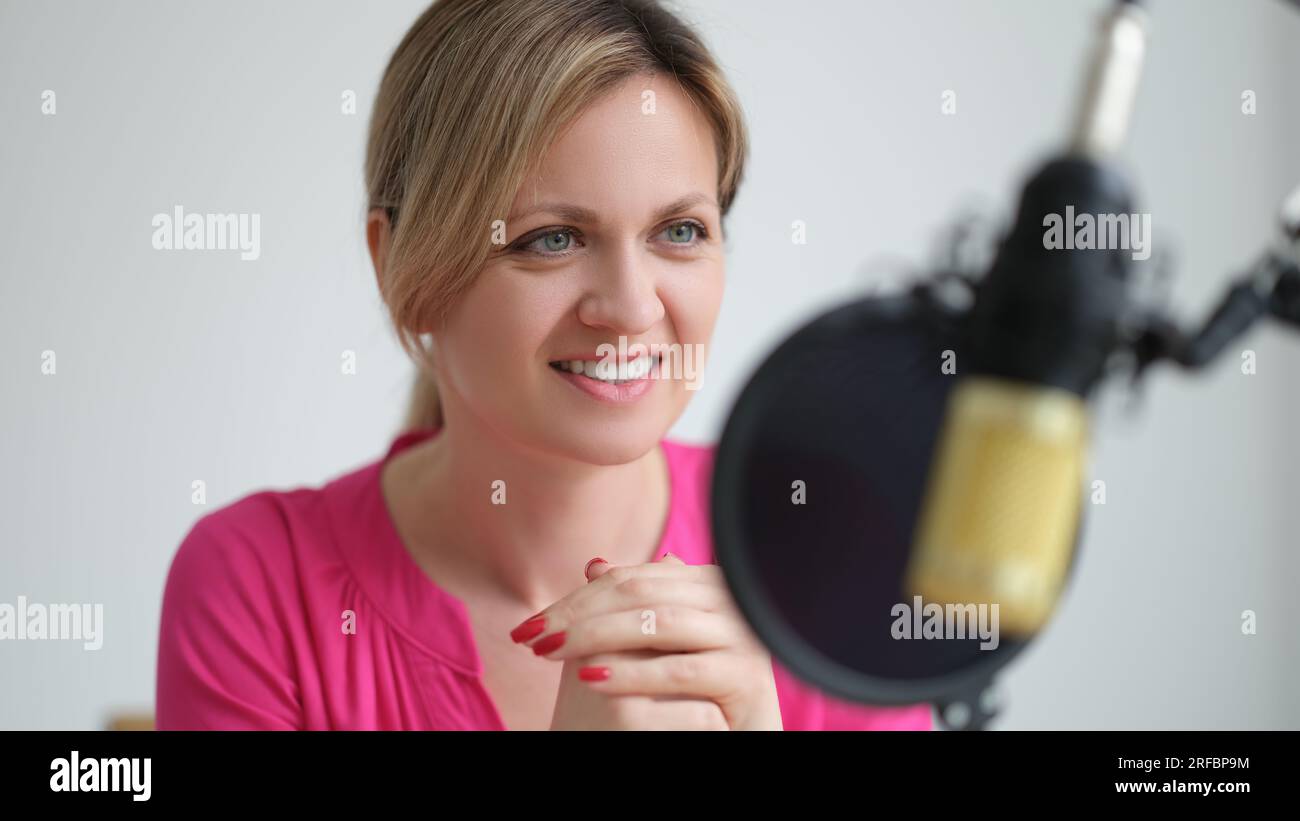 Beautiful smiling woman speaks into microphone at workplace Stock Photo ...