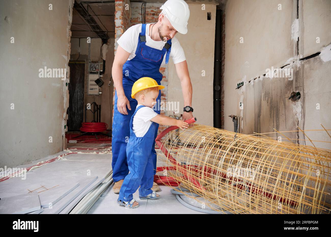 Father and little son working with mesh fiberglass rebar and pipes in ...