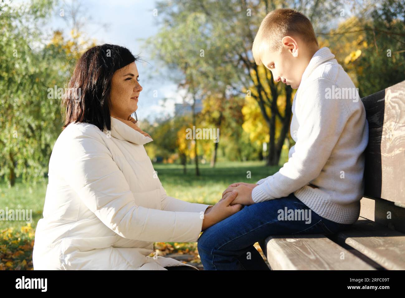 Mother looks at her upset son and listens to his problems. Horizontal ...