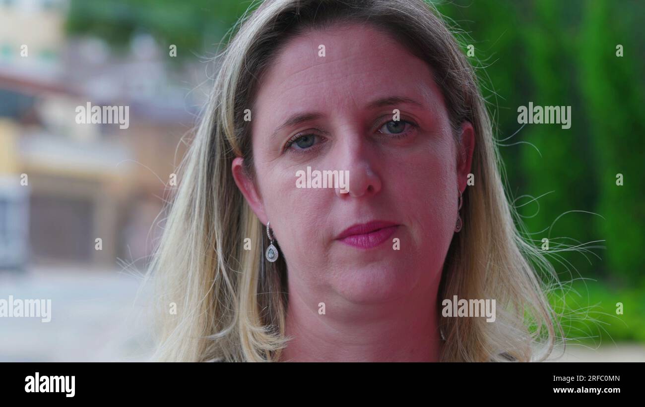 Close-up face of a woman in mid 40s looking at camera with serious ...