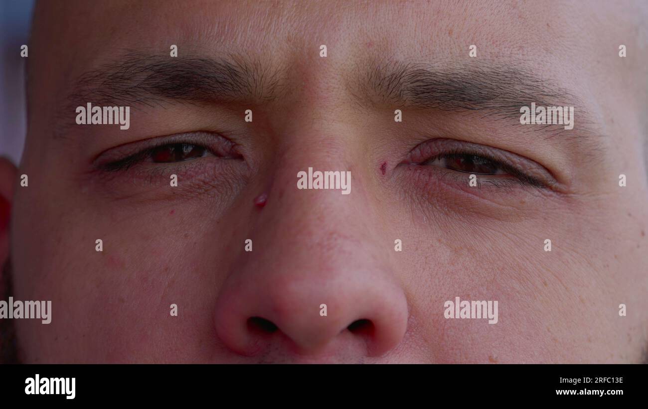 Macro close-up of a man face with judgemental expression. Serious upset ...